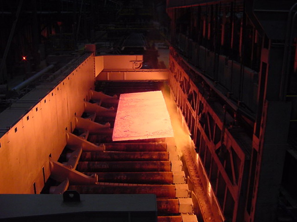 Slab Being Removed from Reheat Furnace – AIM Machinery